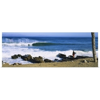 Surfer standing on the beach and looking at surf, Isla Natividad, Baja ...