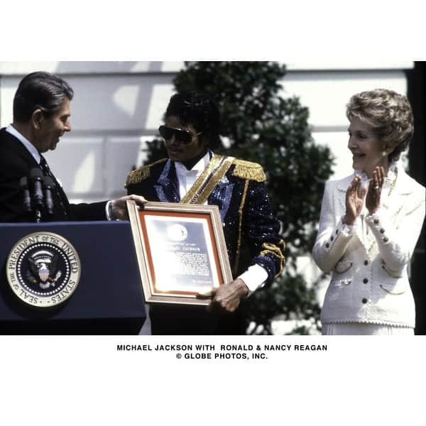 Michael Jackson carrying a plaque on stage with Ronald Reagan and Nancy ...