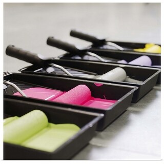 "Close-up side view of trays of coloured paint and paint rollers ...