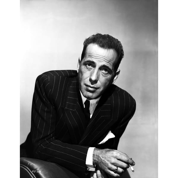 Humphrey Bogart in a suit and tie cuffs showing with a cigarette ...