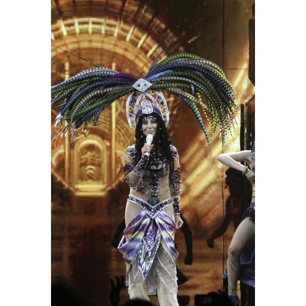 Cher wearing a feather headdress performing in the Dressed To Kill tour ...